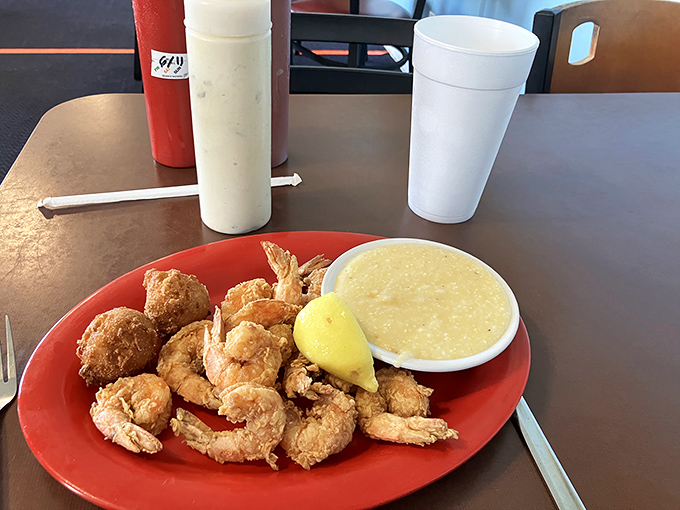Golden-fried shrimp with a side of creamy grits&mdash;a marriage so perfect it should have its own reality show. The lemon wedge isn't just garnish; it's essential punctuation. 