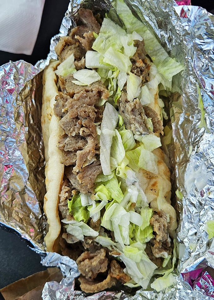 Behold the gyro in all its glory &ndash; seasoned meat embracing crisp lettuce in a warm pita hug, waiting to transport you across oceans with one bite.