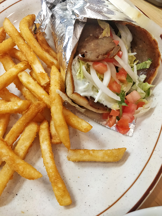 The legendary gyro arrives wrapped like a present, with crispy fries standing guard. One bite and you'll understand why people cross county lines for this Greek masterpiece.
