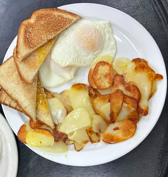 Breakfast perfection on a plate: golden-brown home fries, perfectly cooked eggs, and toast ready for that essential yolk-sopping mission we all live for.