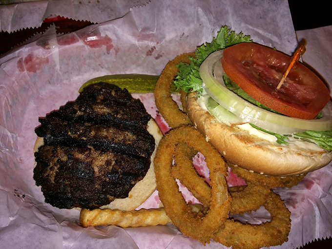 This isn't just a burger—it's a statement. The char marks tell stories of flame-kissed perfection while those onion rings stand guard like crispy sentinels.