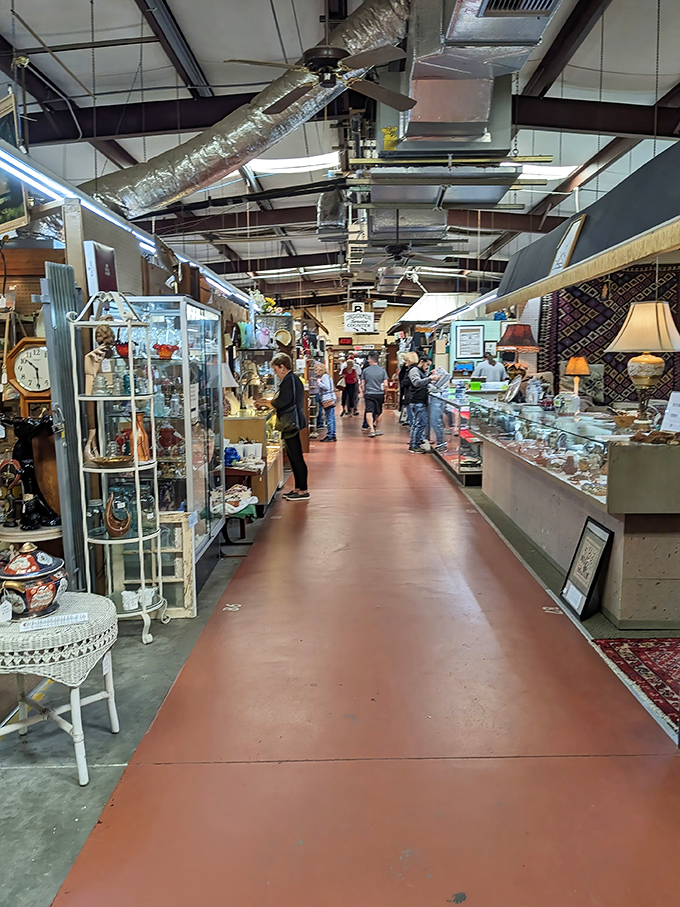 The red-floored hallway stretches like a crimson carpet, inviting curious shoppers to explore glass cases filled with memories someone else made first.