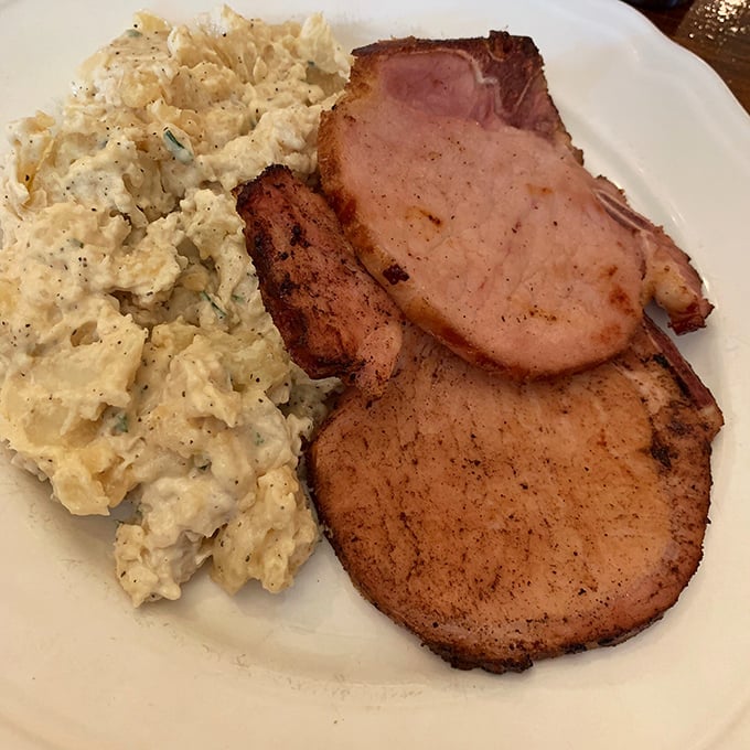 That golden ham paired with legendary German potato salad creates pure comfort food magic on every plate.