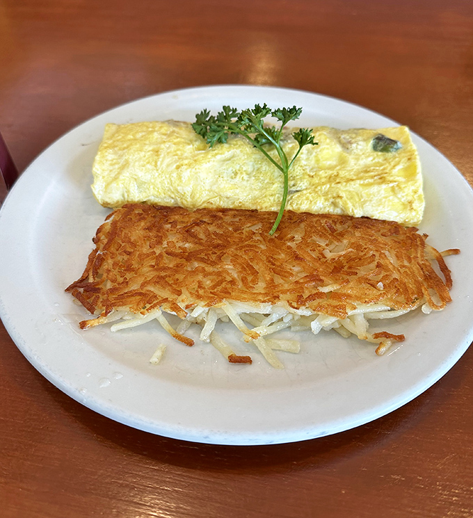 Behold the star of our show: those legendary hash browns with their golden exterior giving way to tender potato beneath&mdash;paired with an omelet that's equally camera-ready.