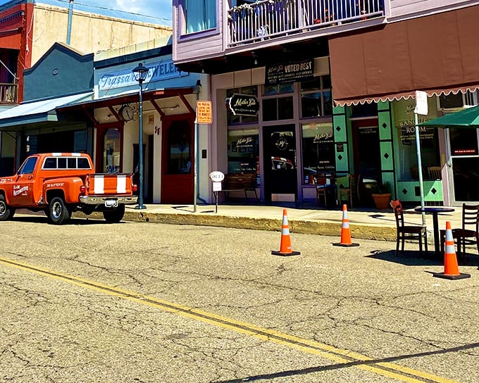 Vibrant storefronts with character to spare. That orange pickup truck isn't just transportation &ndash; it's a lifestyle statement in this unpretentious town.