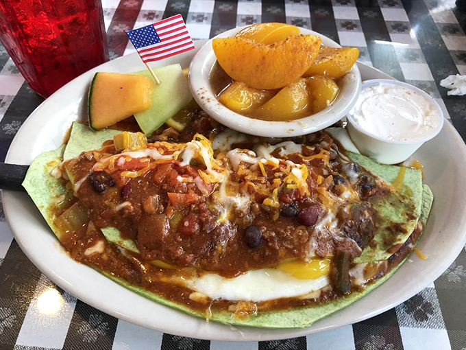 Behold the star attraction: a spinach tortilla cradling eggs beneath a blanket of chili, cheese, and salsa&mdash;breakfast nirvana with a tiny American flag salute.