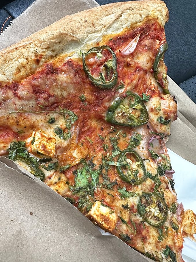 Pizza perfection with an identity crisis! Jalape&ntilde;os, cilantro, and what appears to be paneer create a cross-continental masterpiece that shouldn't work but absolutely does.
