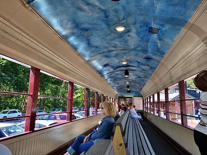 Inside these vintage coaches, blue-painted ceilings mimic the sky while wooden benches invite passengers to slow down and savor the journey, not just the destination.