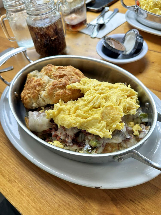 Behold the skillet that launched a thousand road trips. Eggs, potatoes, and enough fillings to make your cardiologist wince with delight.