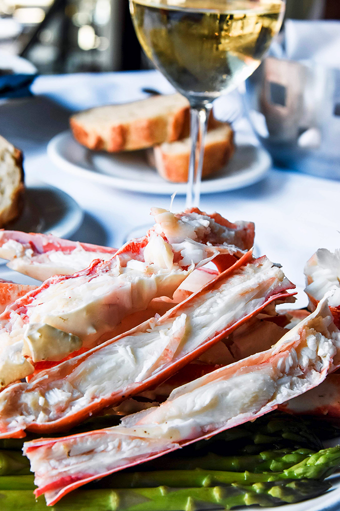 These split king crab legs aren't just dinner&mdash;they're edible architecture. Sweet meat glistening with butter, poised atop vibrant asparagus spears like nature's perfect scaffold.
