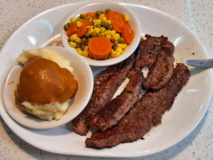A perfectly seared London Broil that makes you wonder why you ever bothered with those fancy steakhouses. The gravy-topped mashed potatoes are basically a hug on a plate.