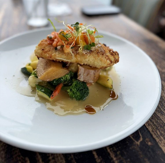 This isn't just fish—it's halibut wearing a macadamia tuxedo, lounging on a bed of vegetables like it's at a spa retreat.