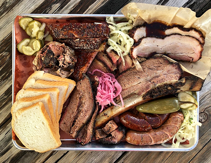 Behold the carnivore's dream platter! This meat mosaic features brisket, ribs, and sausage that would make a vegetarian question their life choices.