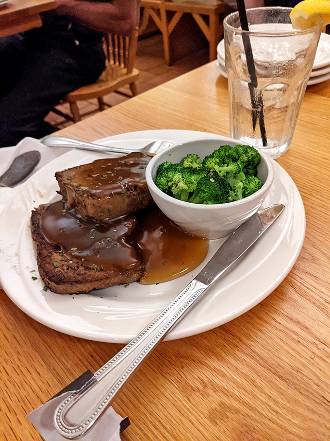 Comfort food poetry: tender meatloaf bathed in savory gravy alongside vibrant broccoli that somehow makes you feel virtuous while indulging.
