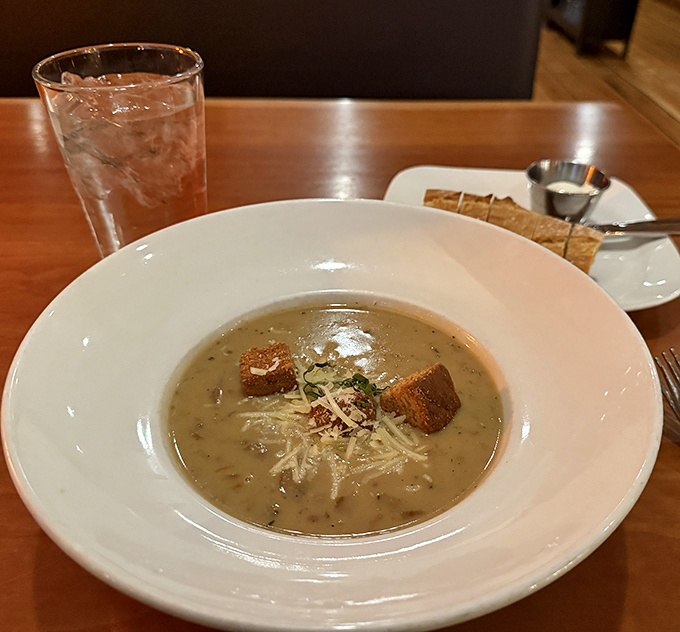 Behold the infamous mushroom soup! Those croutons aren't floating &ndash; they're doing the backstroke in a pool of earthy perfection.
