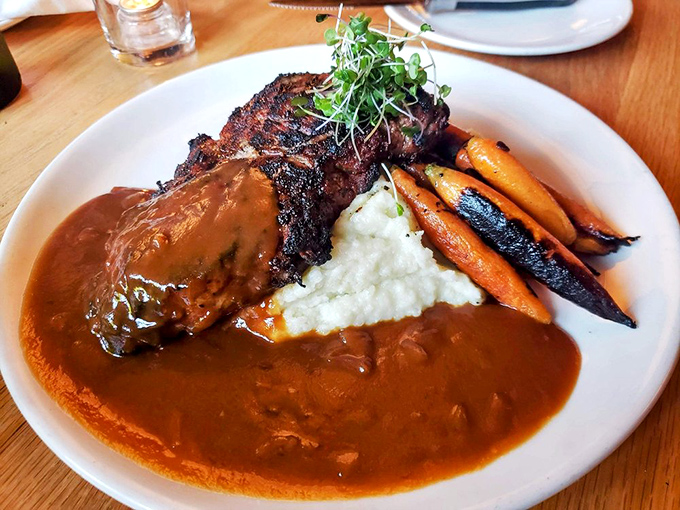 This isn't just a steak, it's a masterpiece of fire and beef&mdash;wood-grilled NY strip nestled on whipped potatoes with charred carrots and a pool of savory onion gravy.