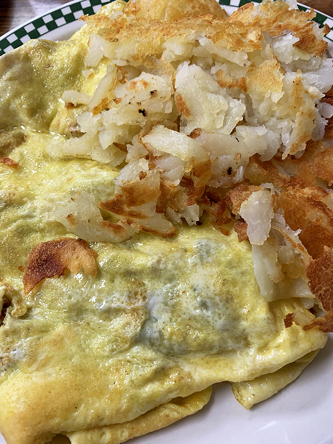 Breakfast nirvana: a perfectly executed omelet alongside crispy hash browns that shatter with each bite. Morning fuel that means business.