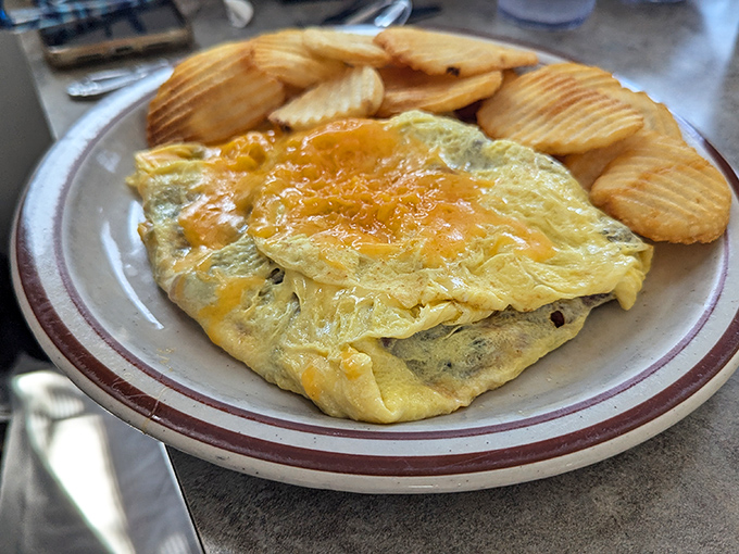 This isn't just an omelet&mdash;it's a golden envelope of cheese-filled promises served with a side of perfectly rippled potato chips.