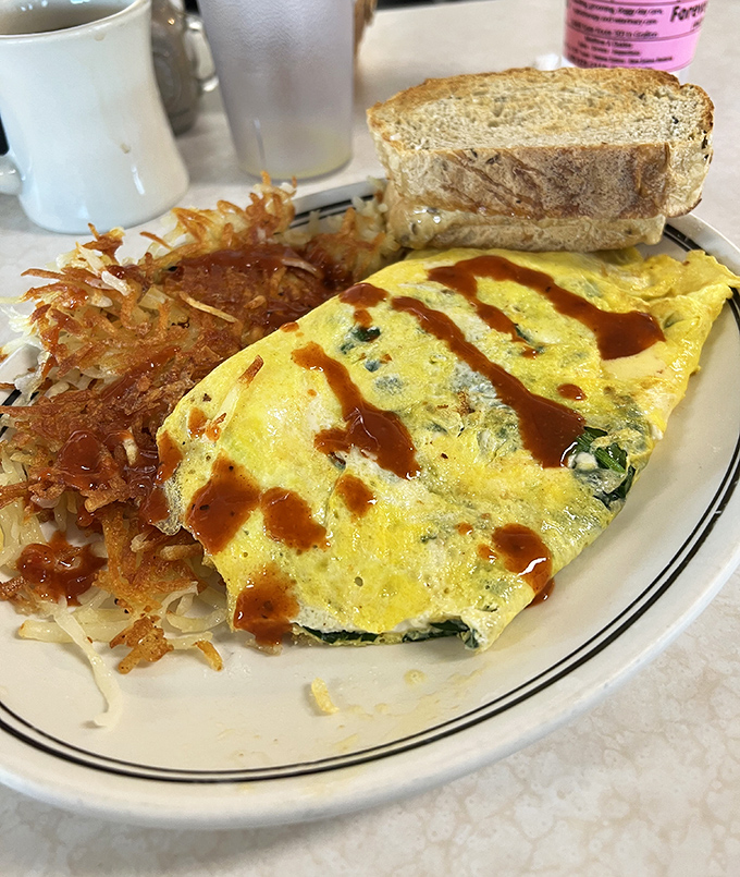 Behold the omelet artistry that transforms simple eggs into golden parcels of pure breakfast bliss.
