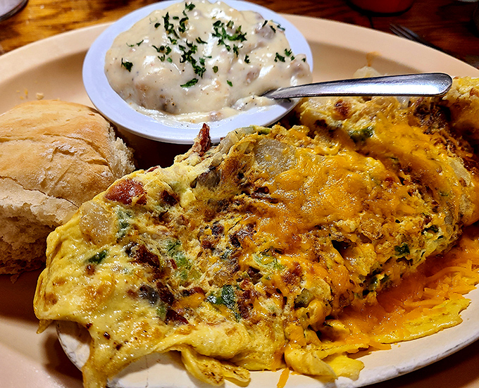 Behold the omelet in its natural habitat&mdash;perfectly folded, generously stuffed, and accompanied by a side of gravy that's practically begging for a biscuit.