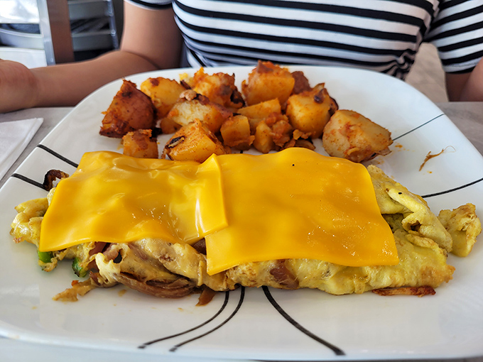 That golden cheese blanket isn't just melted perfection&mdash;it's a sunrise on your plate. Those home fries look like they've been practicing their crispy-outside, fluffy-inside routine for decades.