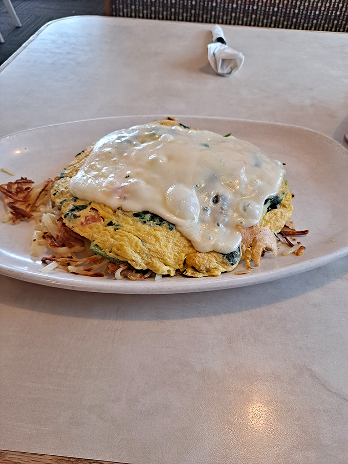 Behold the spinach omelet in all its glory – a perfect marriage of fluffy eggs and savory toppings crowned with hollandaise.