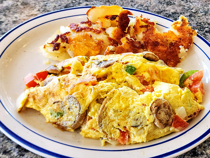 This veggie-packed omelet isn't just breakfast, it's an edible work of art. Those home fries deserve their own fan club.