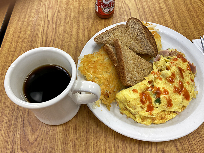 Behold the star of the show: an omelet that's achieved that perfect balance between fluffy and substantial, with hot sauce adding just the right kick.