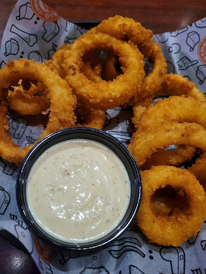 Golden halos of crispy perfection surround tender onion centers. These rings aren't just sides&mdash;they're the main event with a supporting cast of dipping sauce.