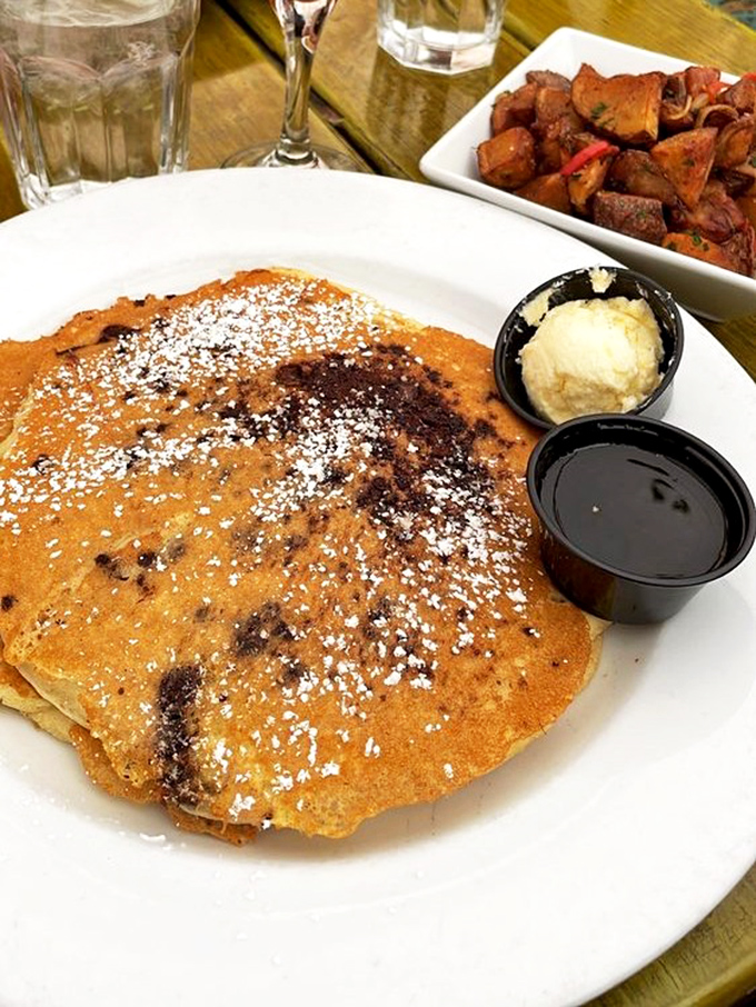 Golden pancakes dusted with powdered sugar, a scoop of butter melting slowly, and maple syrup standing by. Breakfast doesn't get more photogenic.