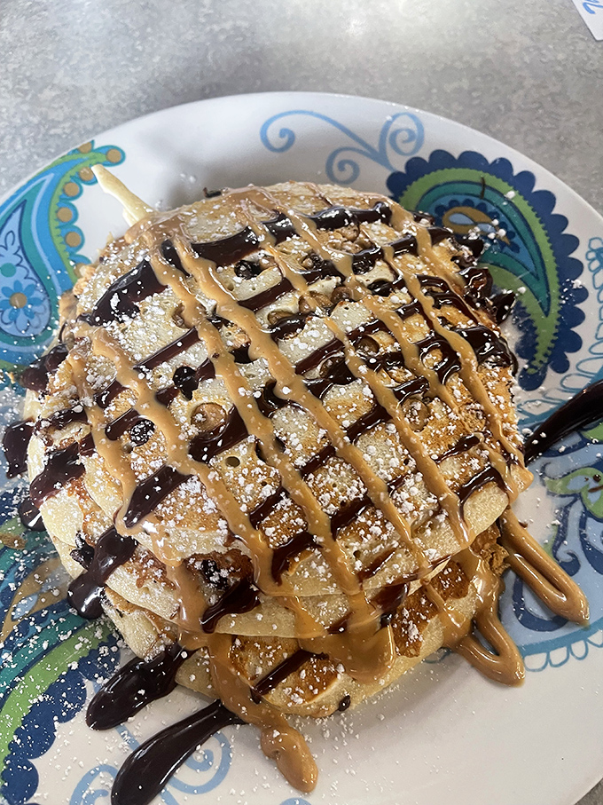 Pancake perfection: chocolate and caramel drizzles creating a crosshatch of joy that would make waffle lovers question their life choices.