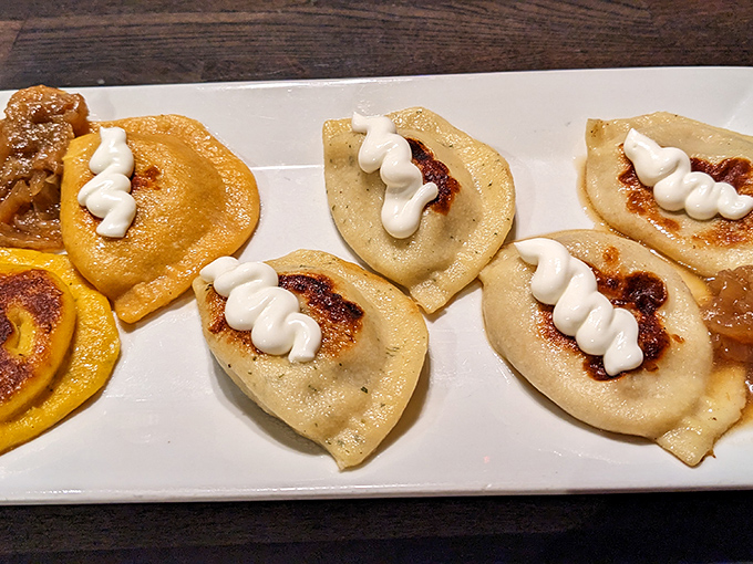 Golden-brown pierogies arrive like little half-moon treasures, topped with a perfect swirl of sour cream and ready for their close-up.
