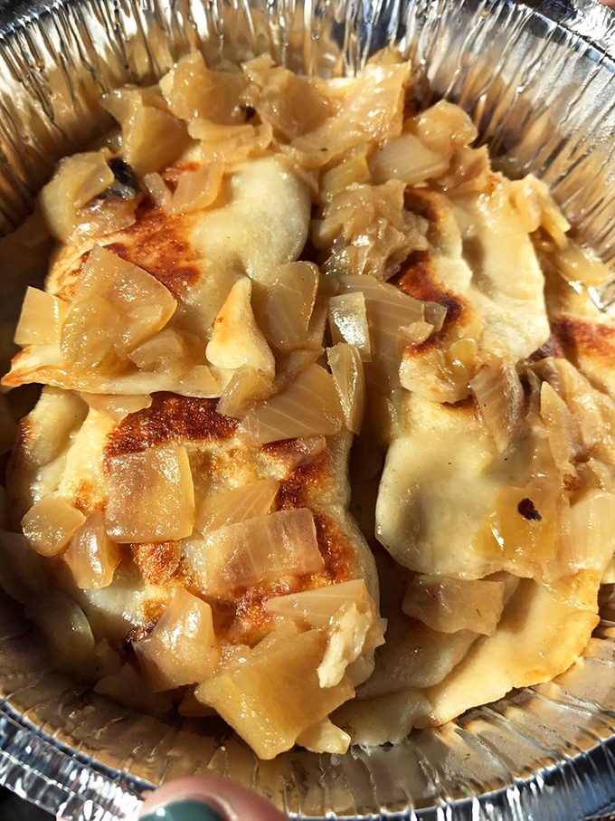 Golden pierogies crowned with caramelized onions prove that sometimes the simplest combinations create the most magic.