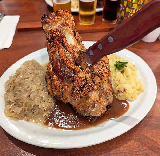 The pork haxen arrives like a medieval feast, surrounded by tangy sauerkraut and that legendary potato salad worth crossing county lines for.