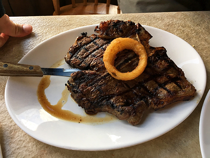 That steak isn't just dinner; it's a religious experience with grill marks. The onion ring crown is a nice touch&mdash;every protein deserves proper regalia.