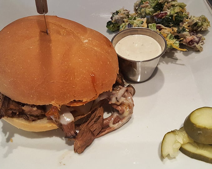 This isn't just a sandwich; it's a pulled pork masterpiece where smoke meets sauce in perfect harmony. The pickle slice stands guard, but resistance is futile.