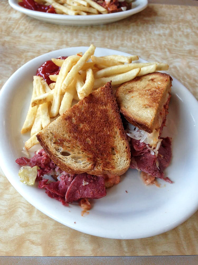 The Reuben that launched a thousand food dreams. Corned beef piled high with sauerkraut and Swiss, perfectly grilled to that ideal crisp-yet-tender sweet spot.