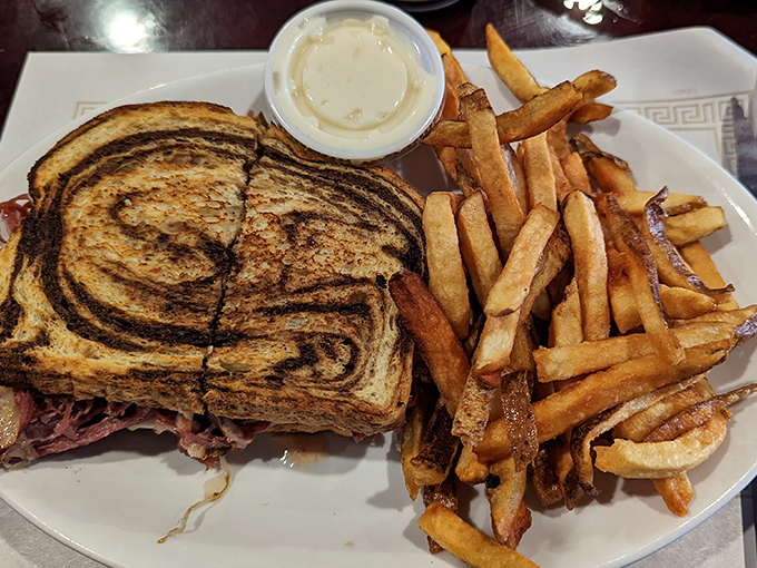 The Reuben in its natural habitat: perfectly grilled marble rye, a generous but not ridiculous stack of corned beef, and those hand-cut fries that put the frozen kind to shame.