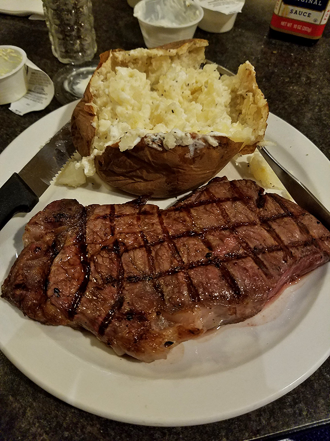 This isn't just a steak&mdash;it's a declaration of beef independence. Perfect grill marks, juicy interior, and a baked potato that could feed a small nation. 