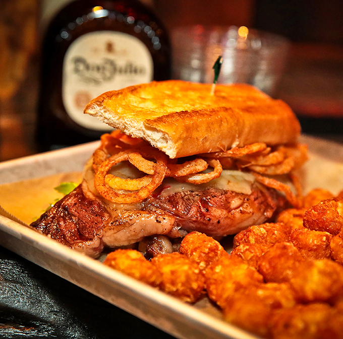 Behold the star of our show: a ribeye sandwich that's not just a meal, but a religious experience with crispy onion rings.