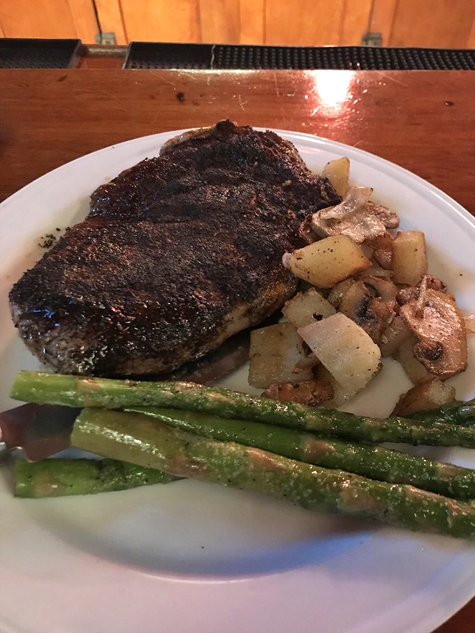 A perfectly seared steak with just the right char, accompanied by roasted potatoes and asparagus&mdash;proof that simplicity executed flawlessly is culinary art.