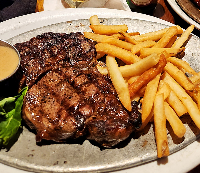 Behold the star of the show—a perfectly charred ribeye with golden fries that would make even the most dedicated cardiologist temporarily suspend judgment.