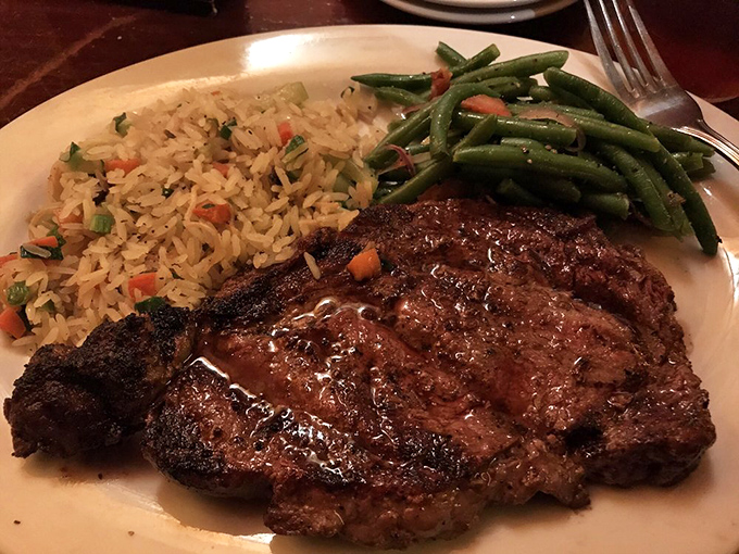 Not all heroes wear capes; some come perfectly seared with rice pilaf and green beans. This ribeye has the kind of char that makes grown adults consider licking their plates.