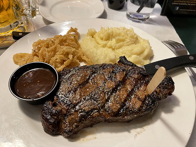 This isn't just a steak; it's a masterpiece of marbling with perfect grill marks, flanked by creamy mashed potatoes and crispy onions that whisper, "Diet starts tomorrow."