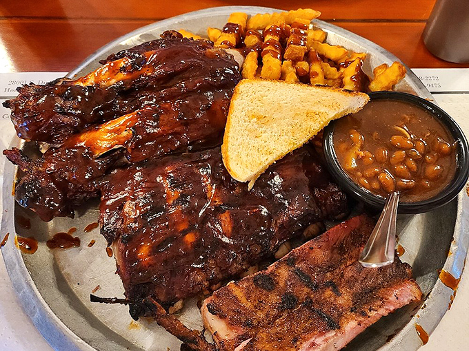 Behold, the holy trinity of barbecue: ribs glistening with sauce, golden fries, and beans that have clearly been introduced to some smoky friends.