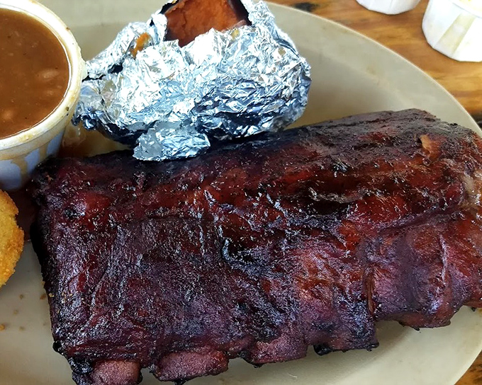 Behold barbecue perfection: ribs with that coveted smoke ring and bark that would make a tree jealous. That side of sauce? Totally optional.