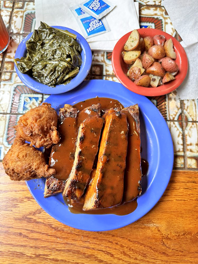 BBQ ribs glistening with sauce, flanked by collard greens and roasted potatoes &ndash; a holy trinity of Southern comfort that speaks directly to your soul.