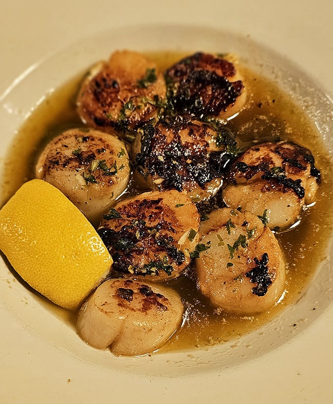 These seared scallops swimming in buttery broth aren't just appetizers—they're little ocean jewels that somehow found their way to landlocked Ohio. The lemon wedge isn't optional, it's essential.