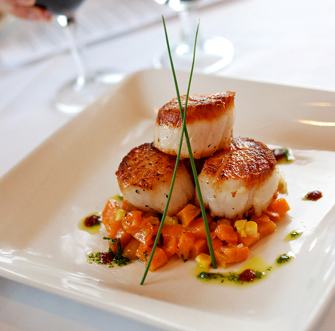 These sea scallops aren't just seared&mdash;they're transformed into caramelized perfection, perched like royalty above a vibrant carrot medley that's playing a delicious supporting role.