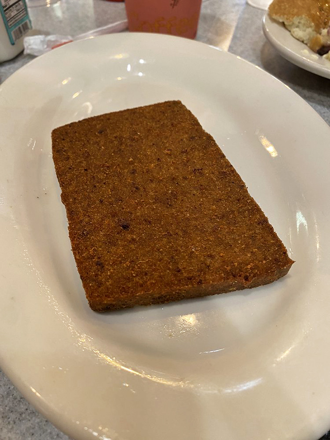 Scrapple: Pennsylvania's culinary dare that rewards the brave. This perfectly crisped slice might just convert you to the church of breakfast meats.